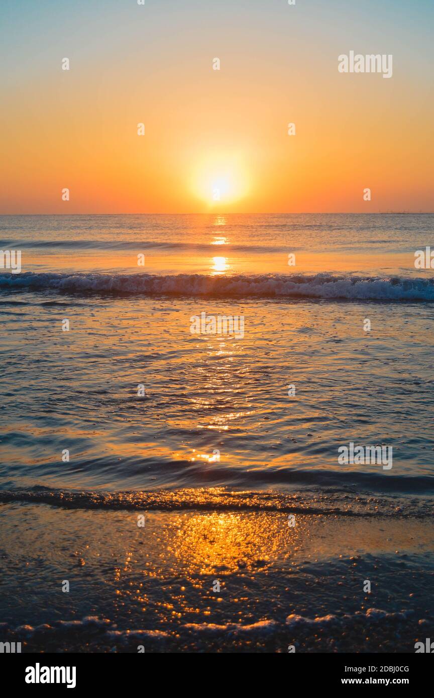 Beautiful summer landscape, sunset at the beach, sparkly sand and waves ...