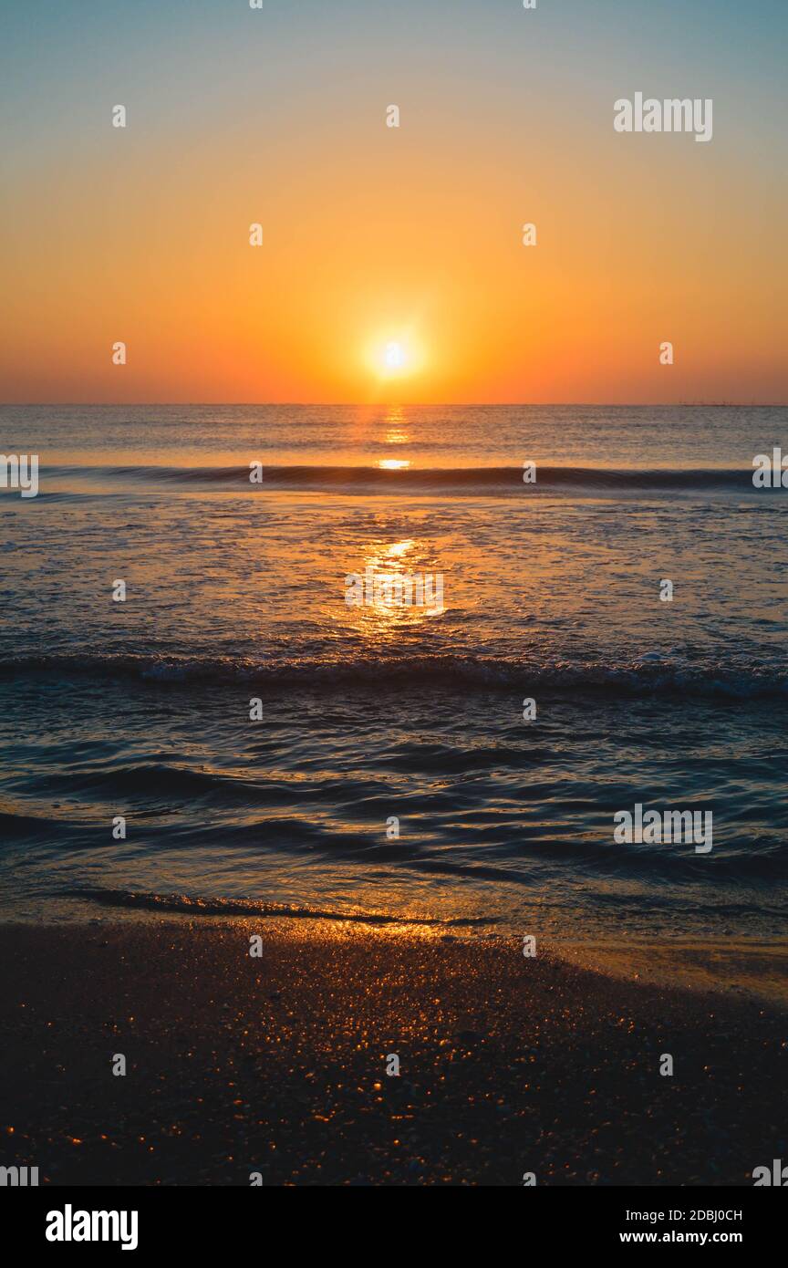Beautiful summer landscape, sunset at the beach, sparkly sand and waves ...