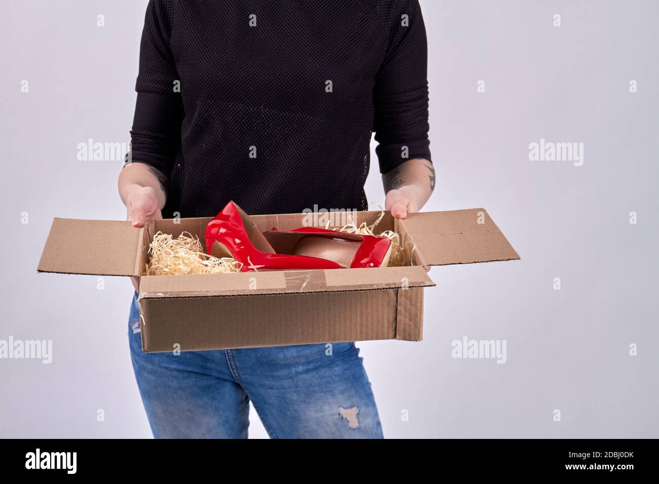 Portrait of girl unboxing a parcel with red shoes Stock Photo - Alamy