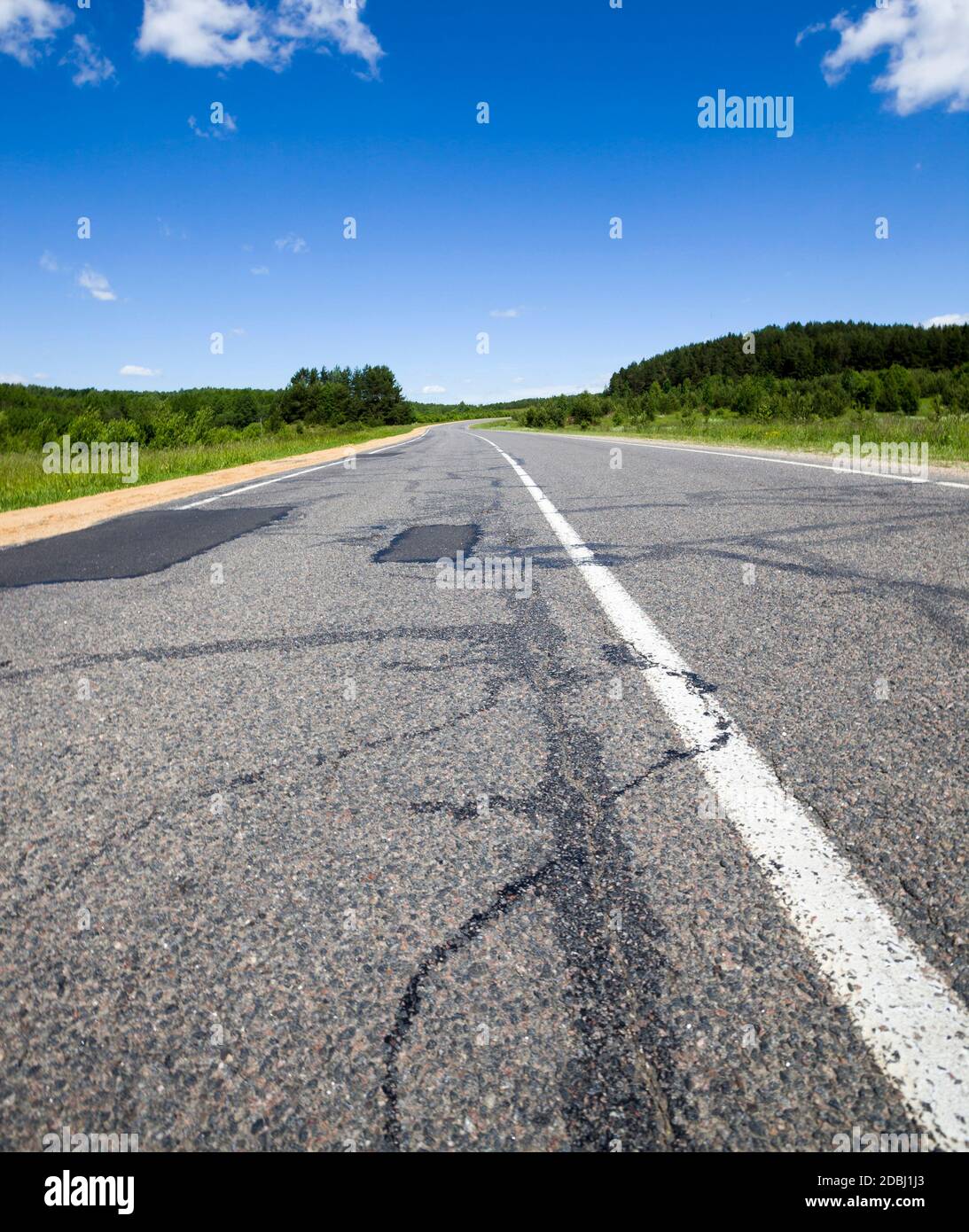 asphalt road with white road markings, the road is not good quality ...