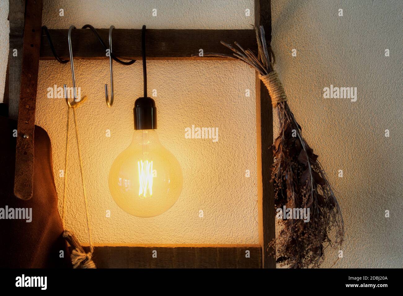 Retro light bulb hanging near white wall with modern decoration, home ...