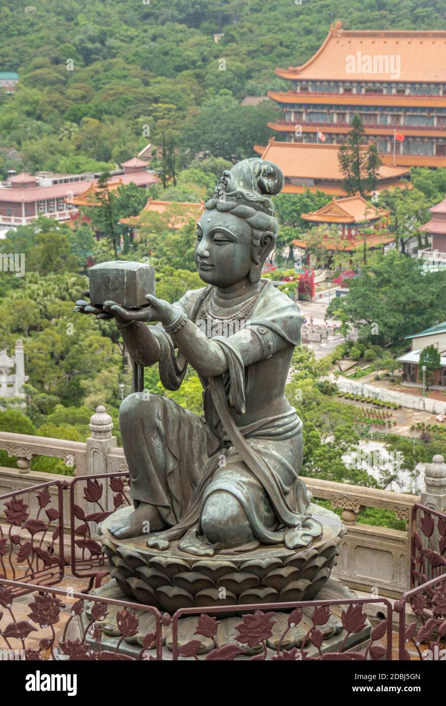 Buddhist Deva statue offering incense to the Tian Tan Big Buddha statue ...