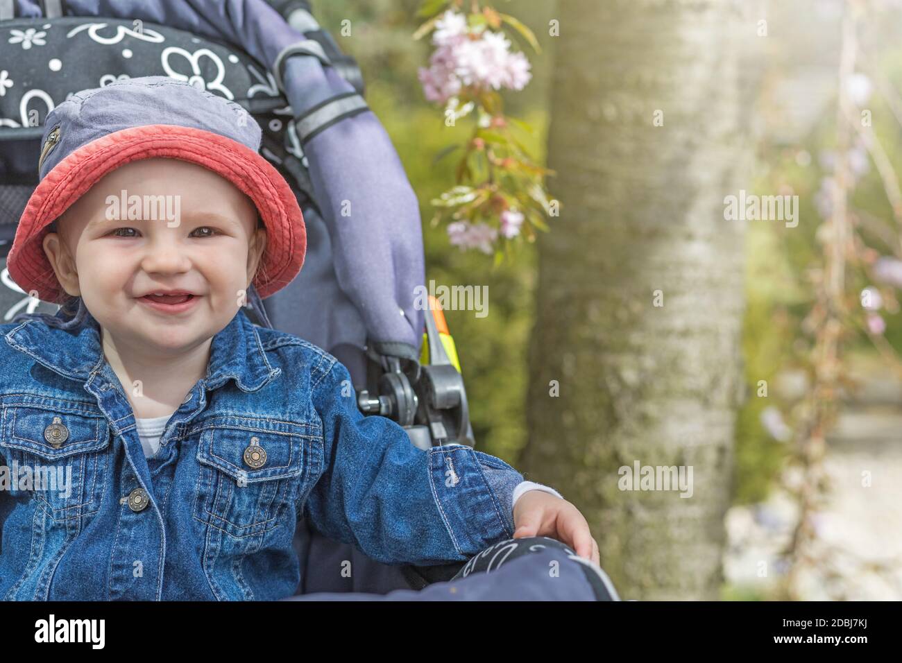 Cute little baby boy sitting in stroller smiling at the camera Stock ...