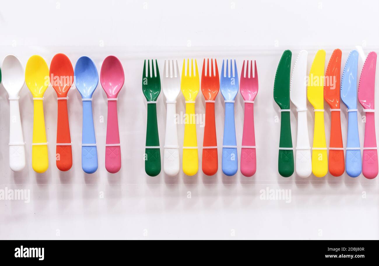 Multi-colored plastic cutlery for a children's party Stock Photo - Alamy