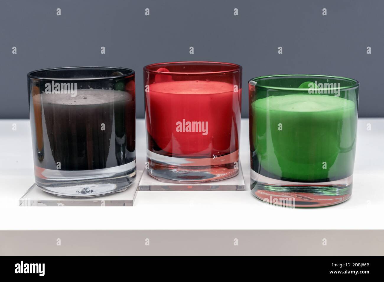 Red, black and green scented candles in transparent candlesticks Stock ...