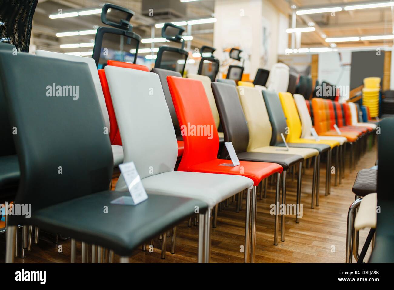 Rows of different chairs in furniture store showroom, nobody. Seats ...