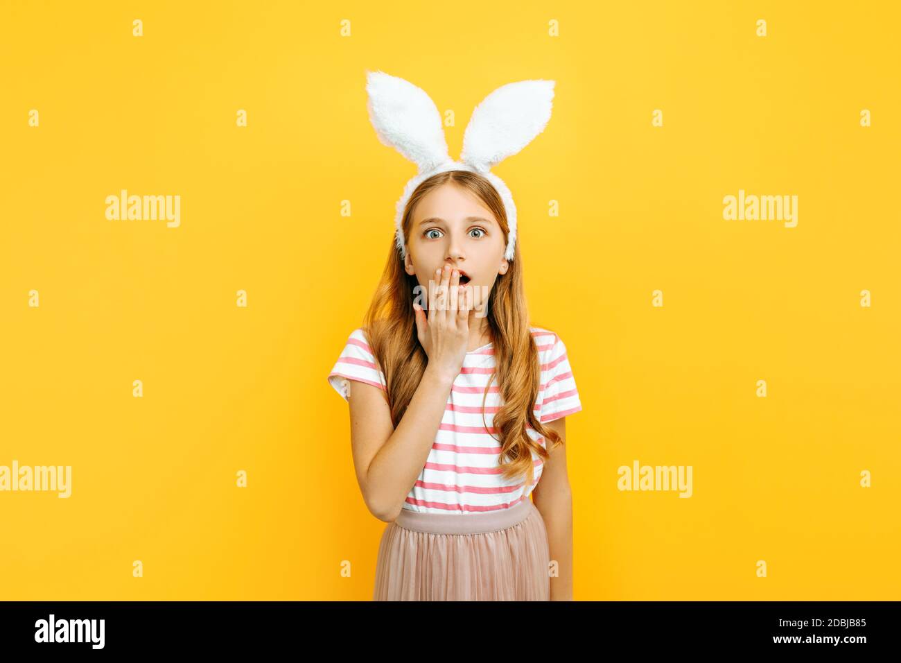 Shocked little beautiful girl on the head with rabbit ears, surprised ...