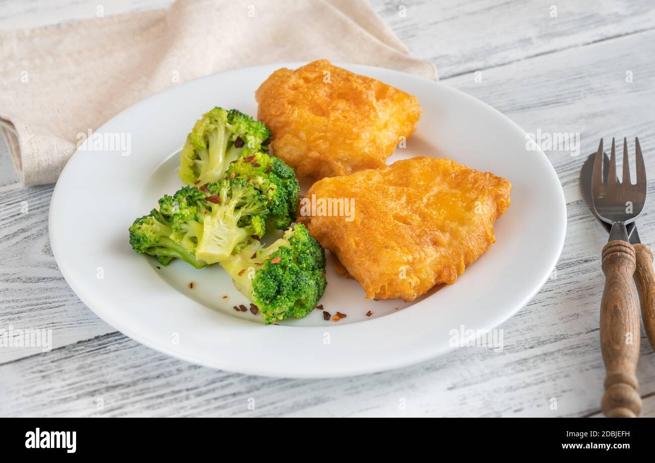 Portion of battered fish with steamed broccoli Stock Photo - Alamy