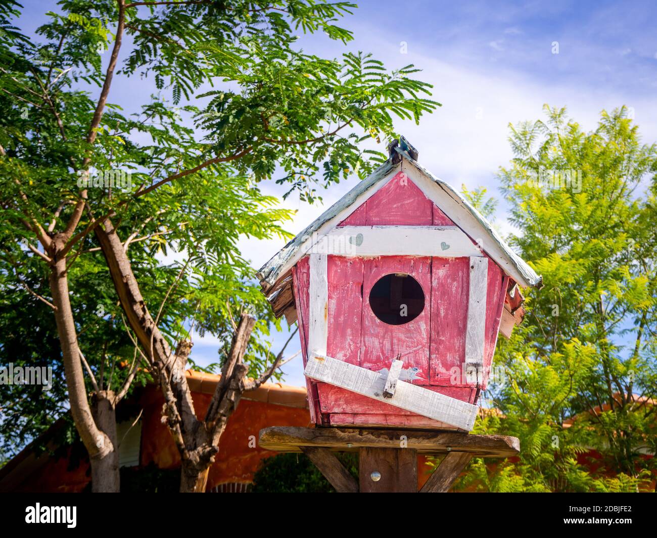 red Wooden bird house in the garden and tree Stock Photo - Alamy
