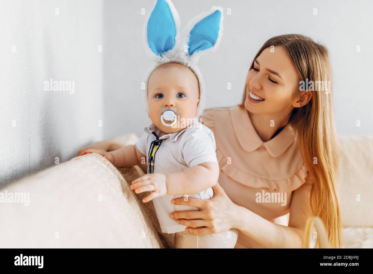 Mom and baby with rabbit ears, with Easter eggs in their hands, sitting ...
