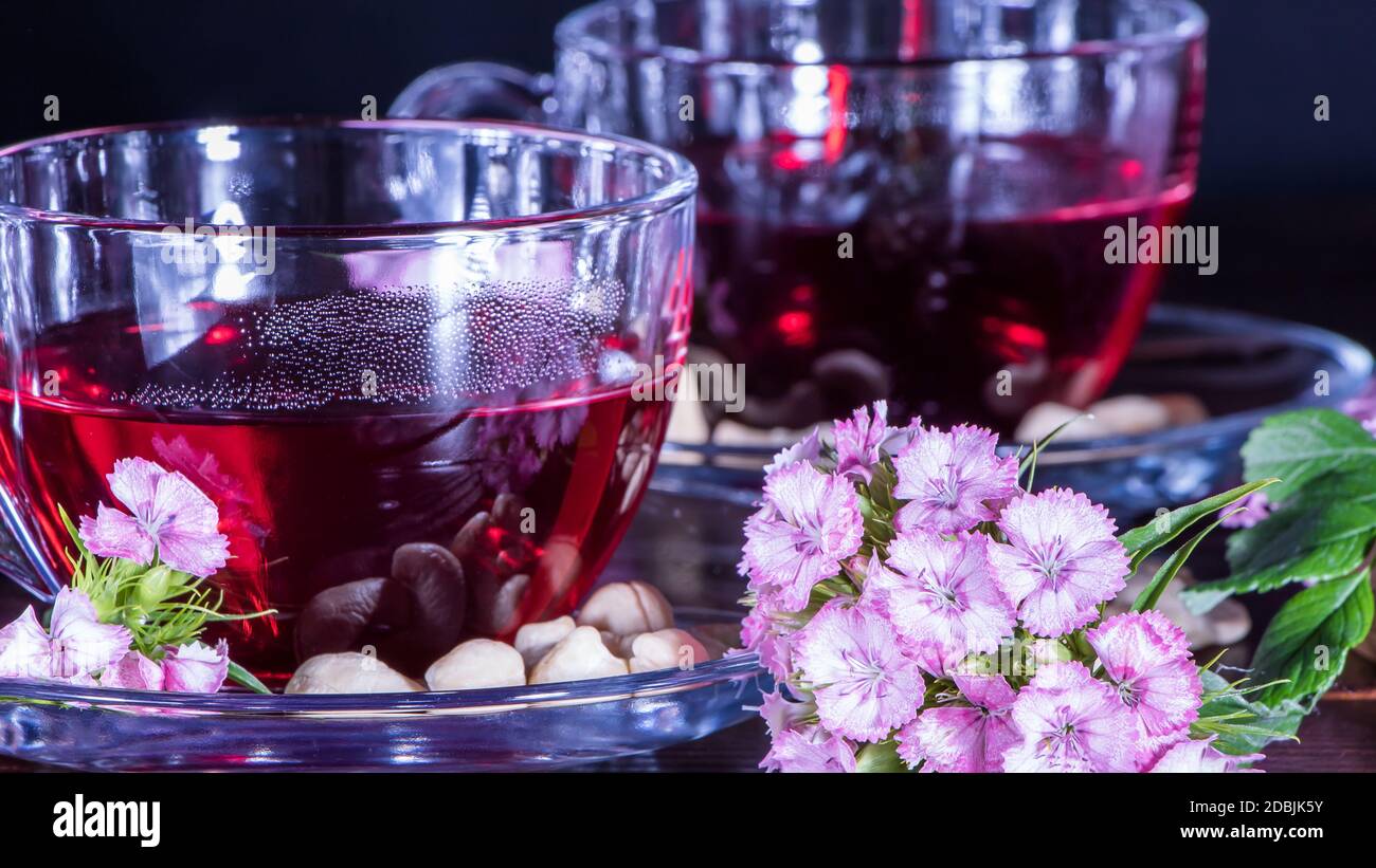 Hibiscus Red tea mug with carnation flowers close-up horizontal photo ...
