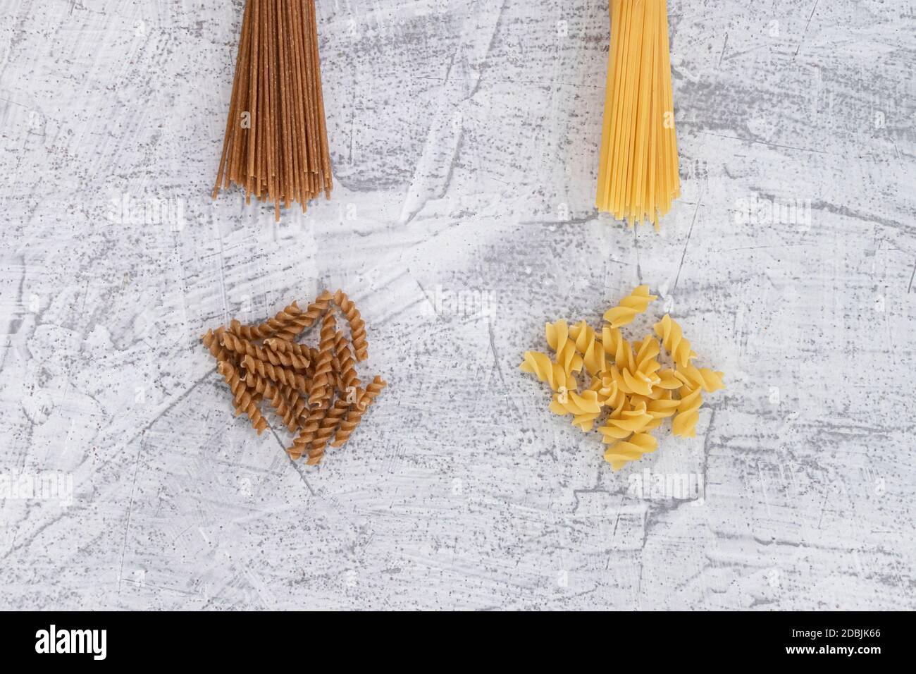 Bran pasta. Various pasta on a white stone background. View from above ...