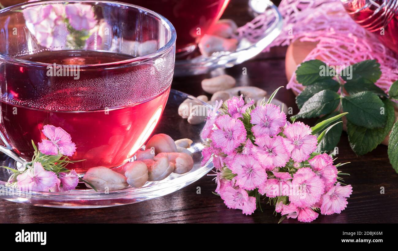 Hibiscus Red tea mug with carnation flowers close-up horizontal photo ...