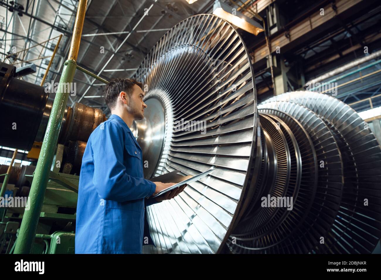 Male engineer checks turbine impeller vanes on factory. Industrial ...