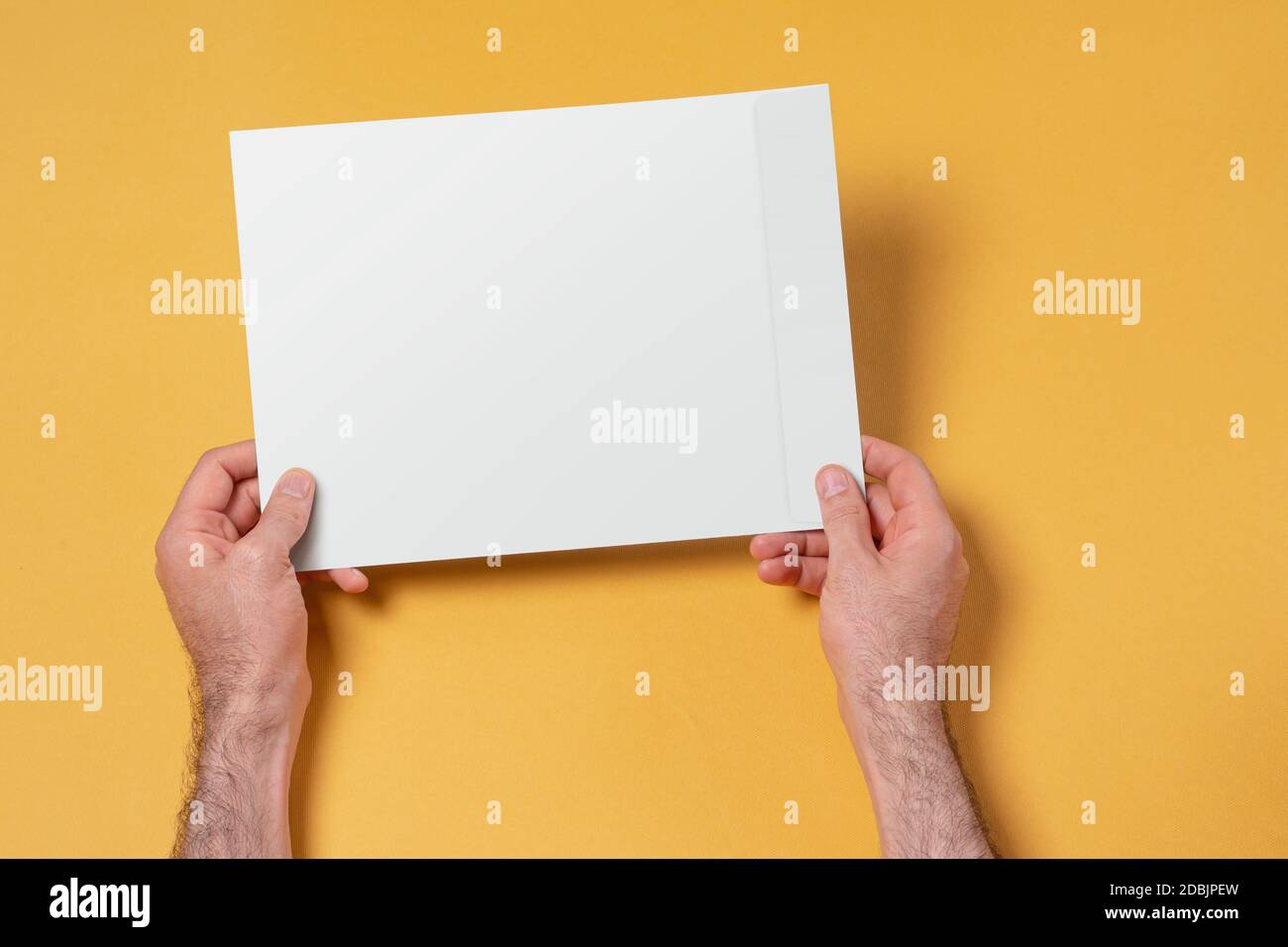 Male hands holding an A4 paper envelope, editable mock up template for ...