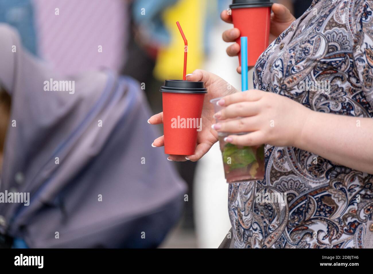 Crop woman with drinks to go on street Stock Photo - Alamy