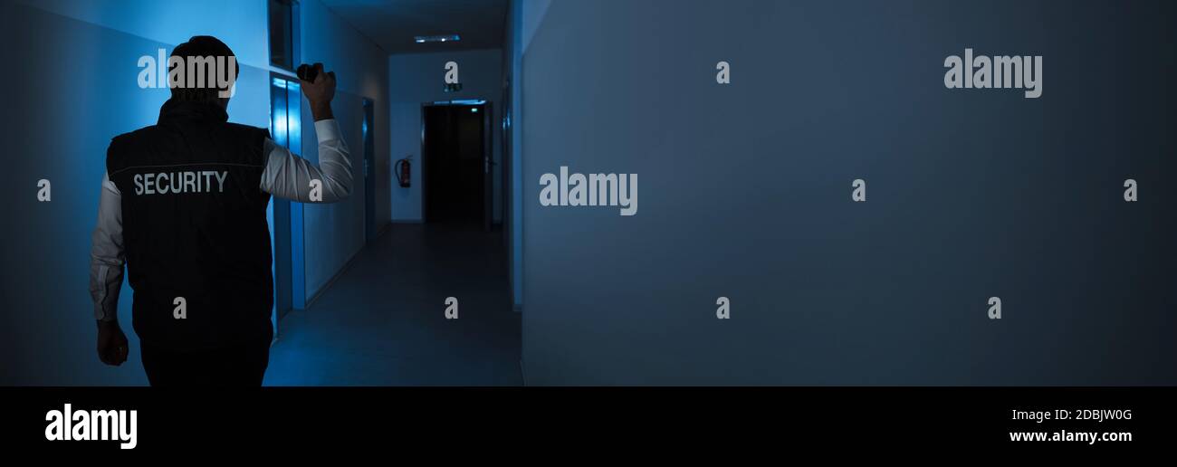 Security Guard At Night With Flashlight Inside Building Stock Photo - Alamy