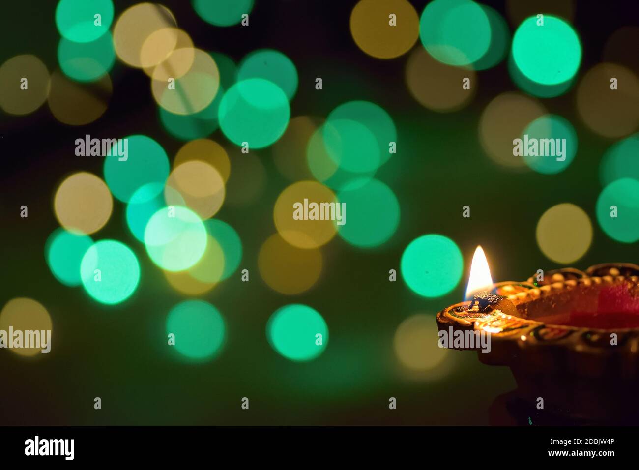 Colorful traditional Diwali oil lamp with blurred background lights ...
