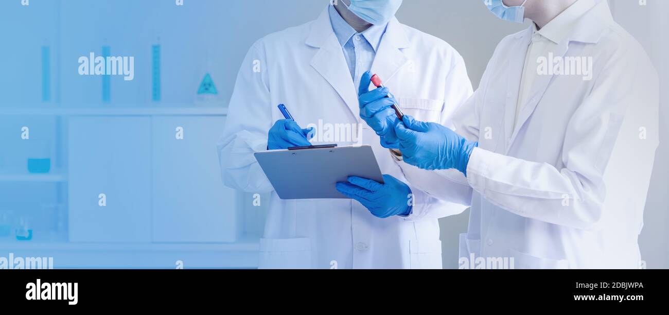 Covid-19 testing in laboratory. Scientists looking at blood samples of ...