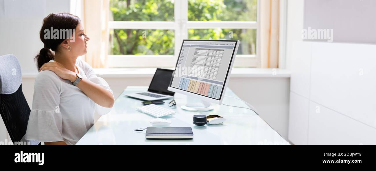 Businesswoman Having Shoulder Pain While Working At Computer Desk In ...