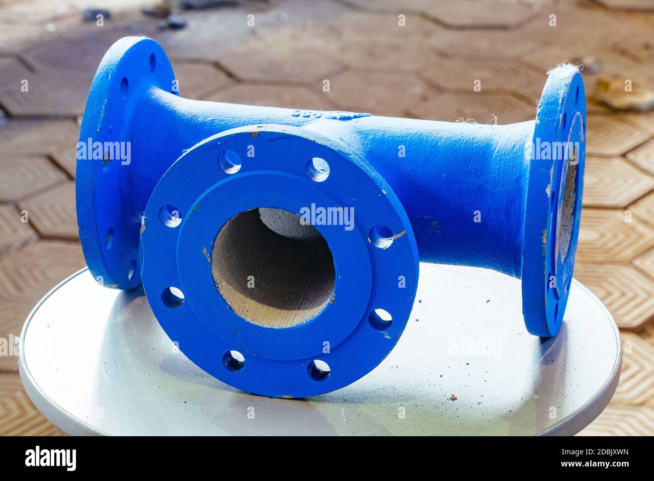 Cast metal pipe T shape connection with flange on gray table Stock ...