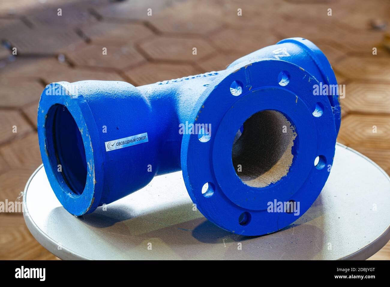 Cast metal pipe T shape connection with flange on gray table Stock ...