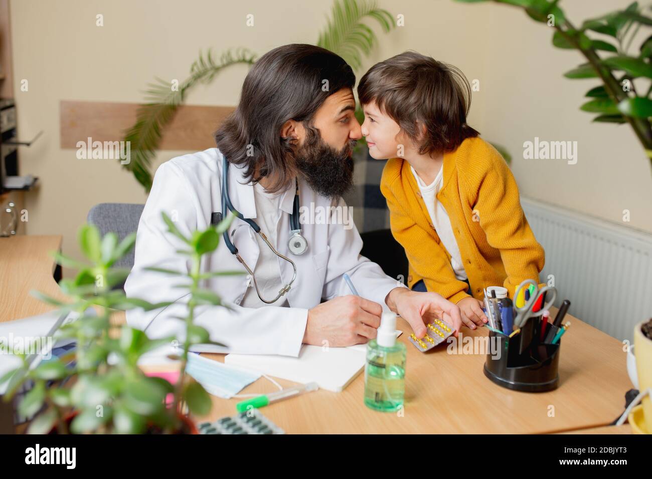 Paediatrician doctor examining a child in comfortabe medical office ...