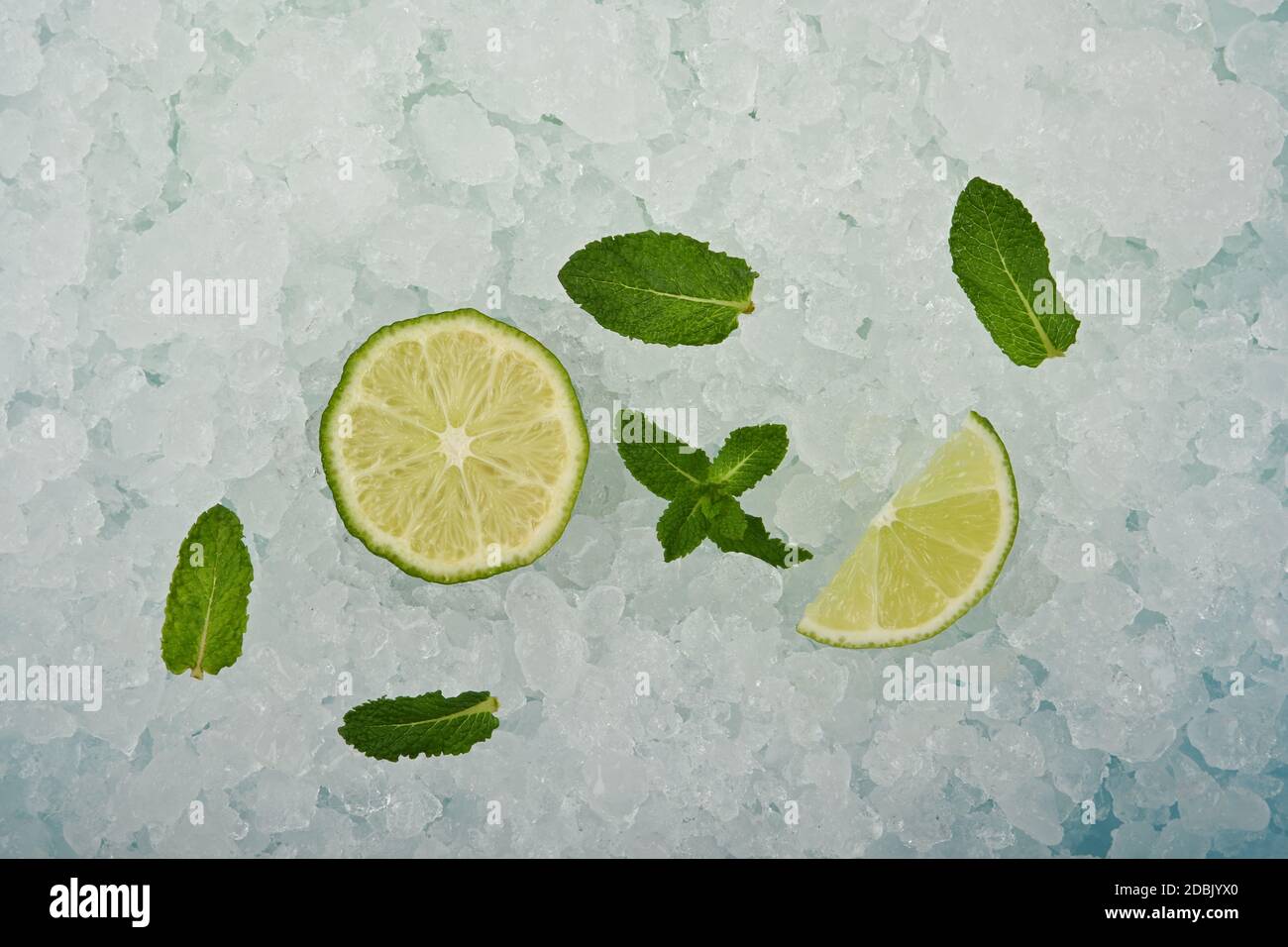 Close up fresh juicy green lime cut half and wedge slice and mint ...