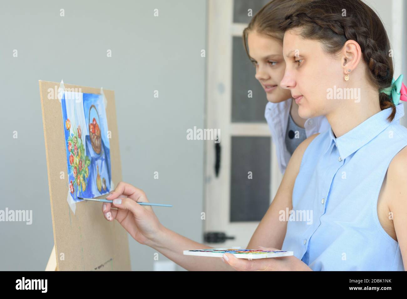 teacher teaches to paint the student with paints on the easel Stock ...