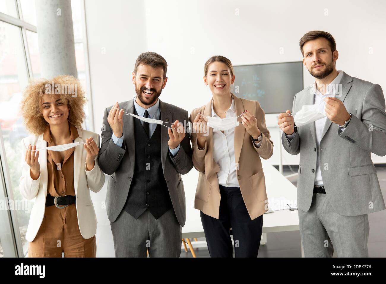 Portrait of young business people taking off their protective face ...