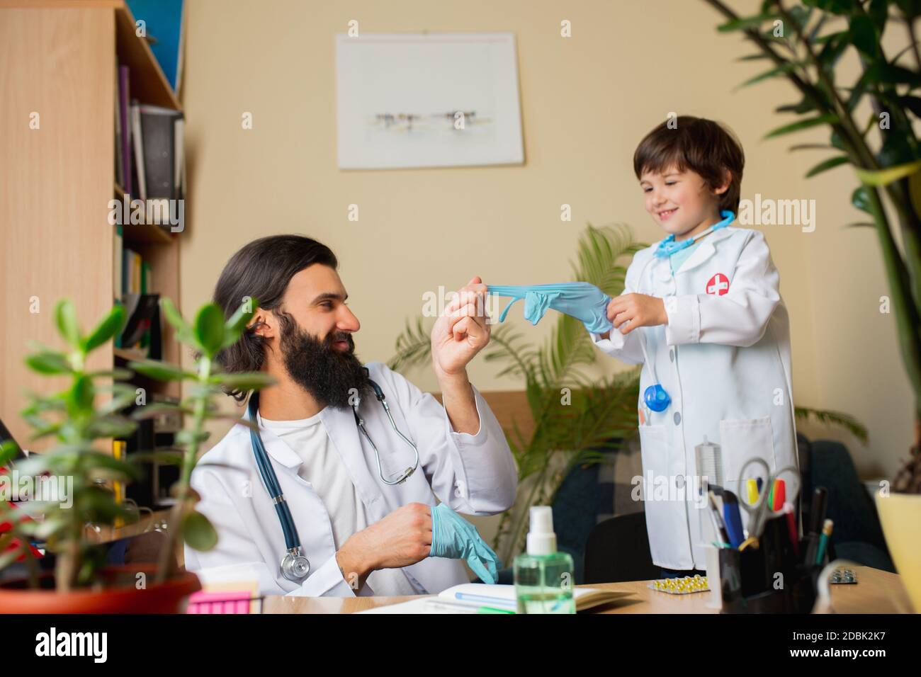 Paediatrician doctor examining a child in comfortabe medical office ...