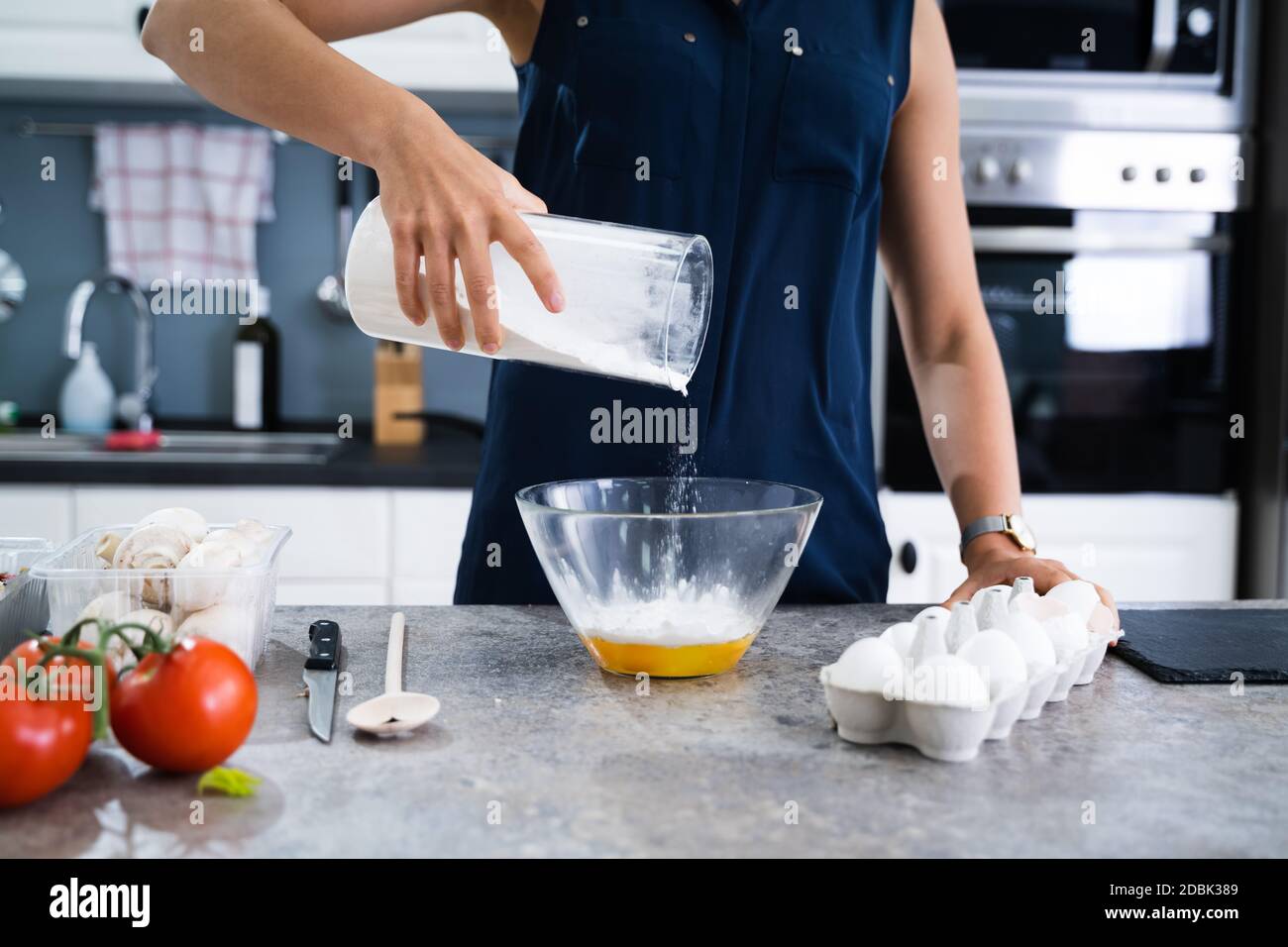 Woman Cooking Food At Home Adding Flour Stock Photo - Alamy