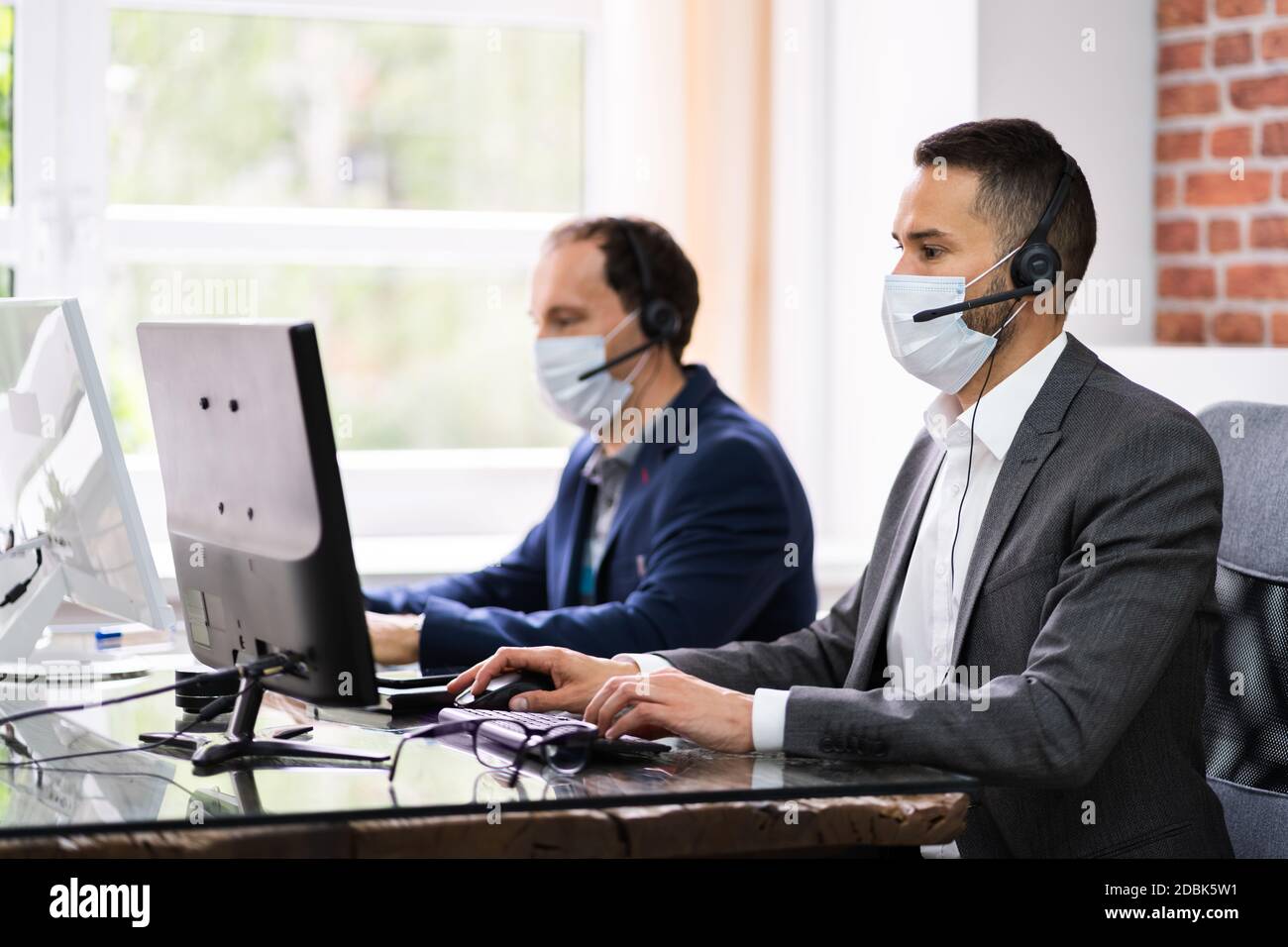 Customer Service Support Agents In Headsets And Face Masks Stock Photo ...