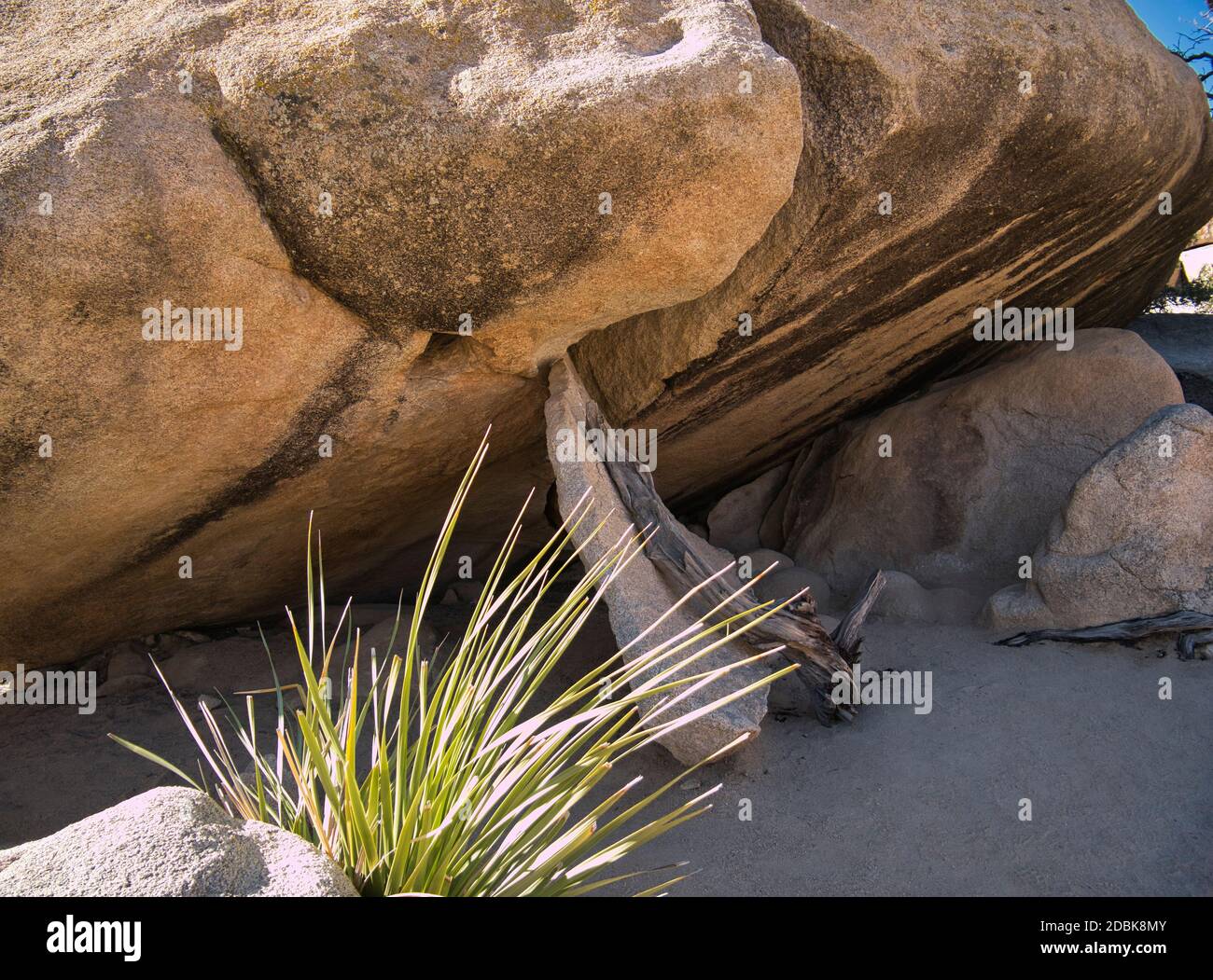 Small boulders lie under a heavy boulder Stock Photo - Alamy