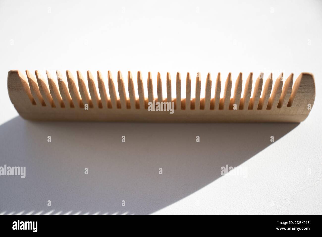 Thin comb of light wood on a white background Stock Photo - Alamy