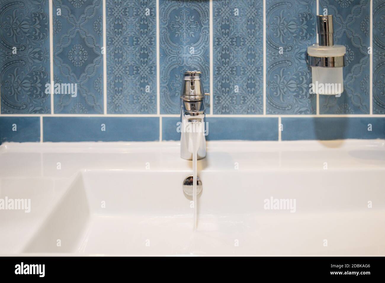 Faucet and water flow on bathroom Stock Photo - Alamy
