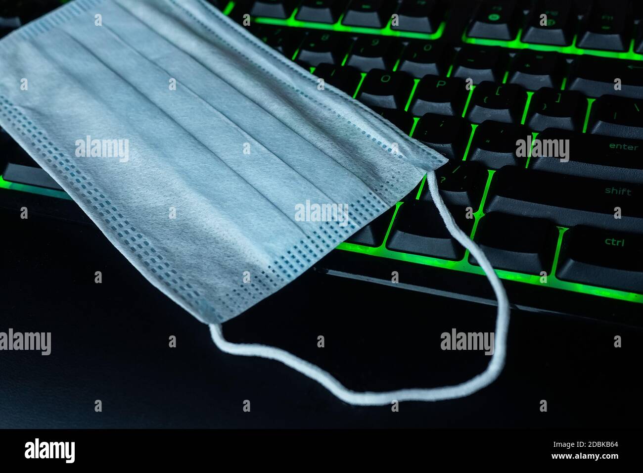 A surgical mask is placed on the keyboard of a laptop Stock Photo - Alamy