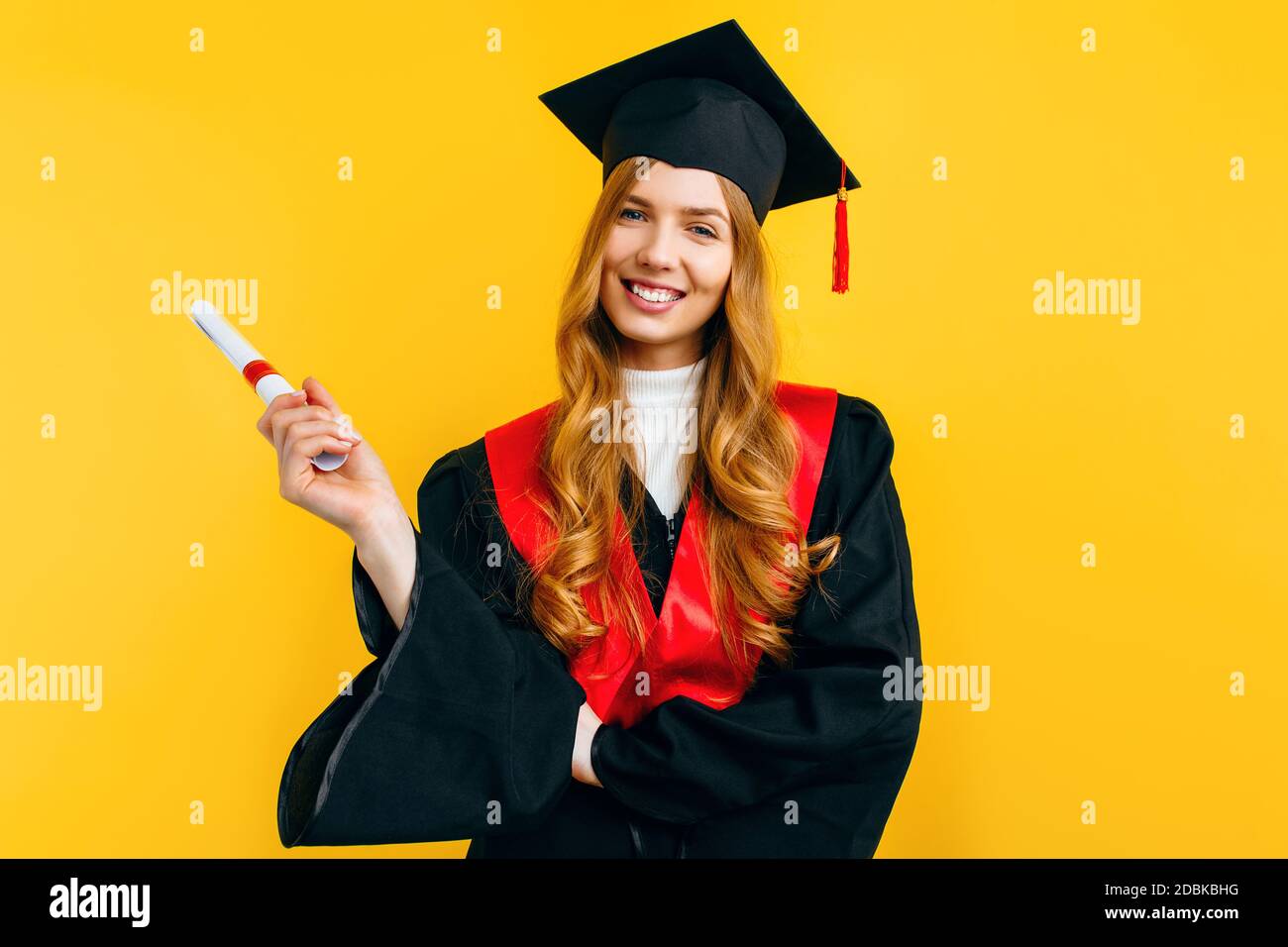 Happy attractive graduate in a master's dress, with a diploma on a ...
