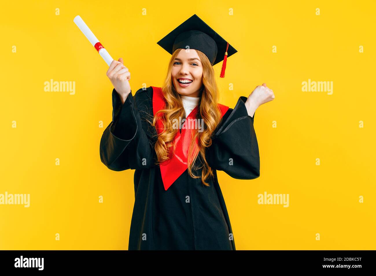 Happy graduate girl with a diploma, shows a gesture of victory and ...