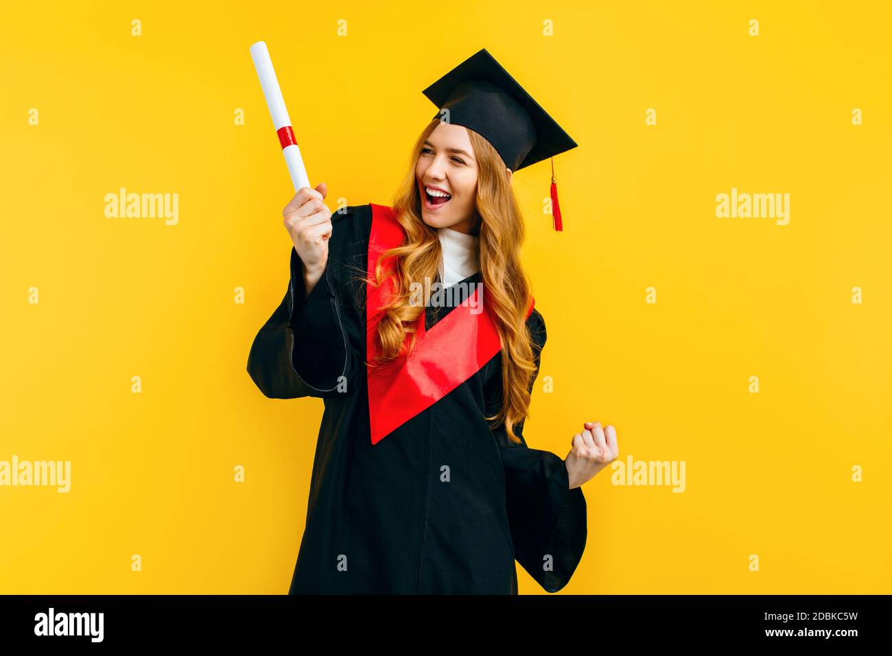 Happy graduate girl with a diploma, shows a gesture of victory and ...