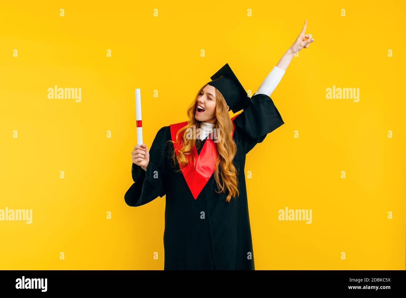 Happy graduate girl with a diploma, shows a gesture of victory and ...