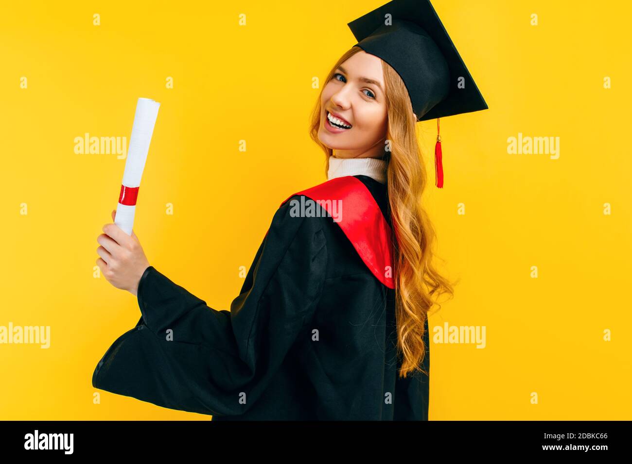 Happy attractive graduate in a master's dress, with a diploma on a ...