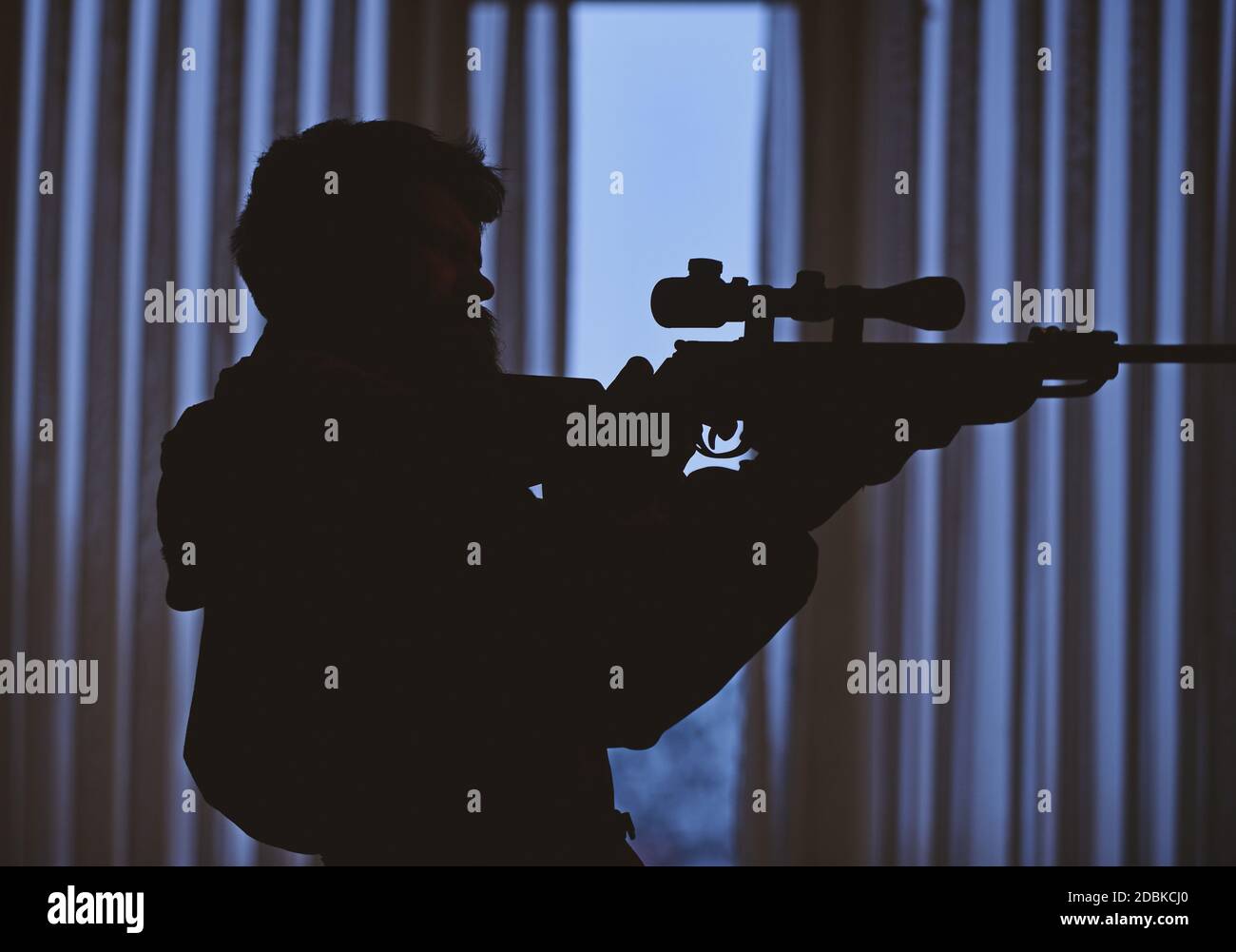 Silhouette of macho aiming at victim in front of window. Hunter ...