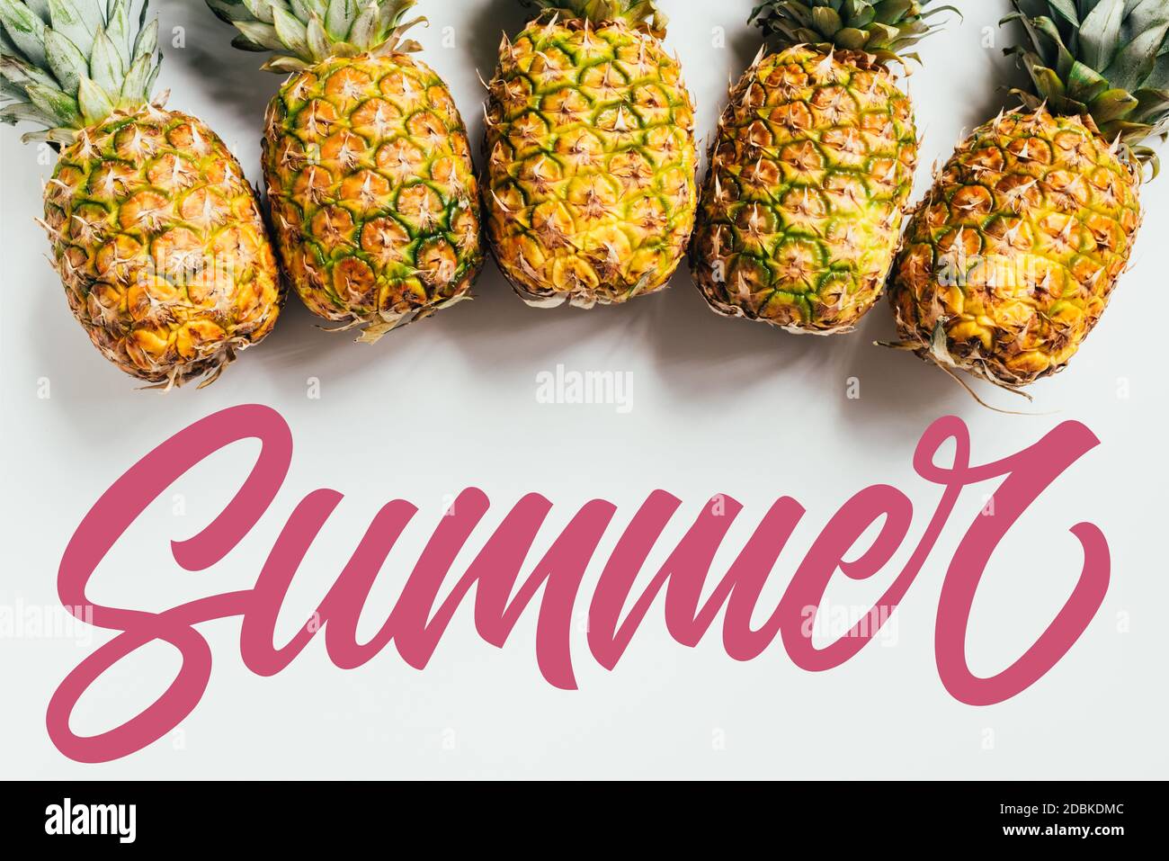 top view of fresh ripe pineapples with green leaves on white background ...