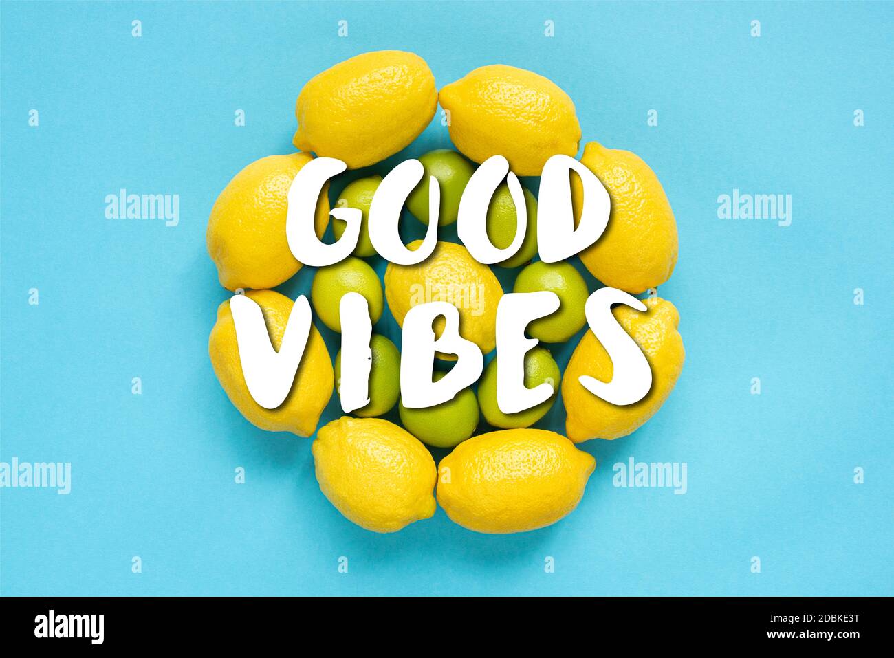 top view of ripe yellow lemons and limes arranged in circles on blue ...