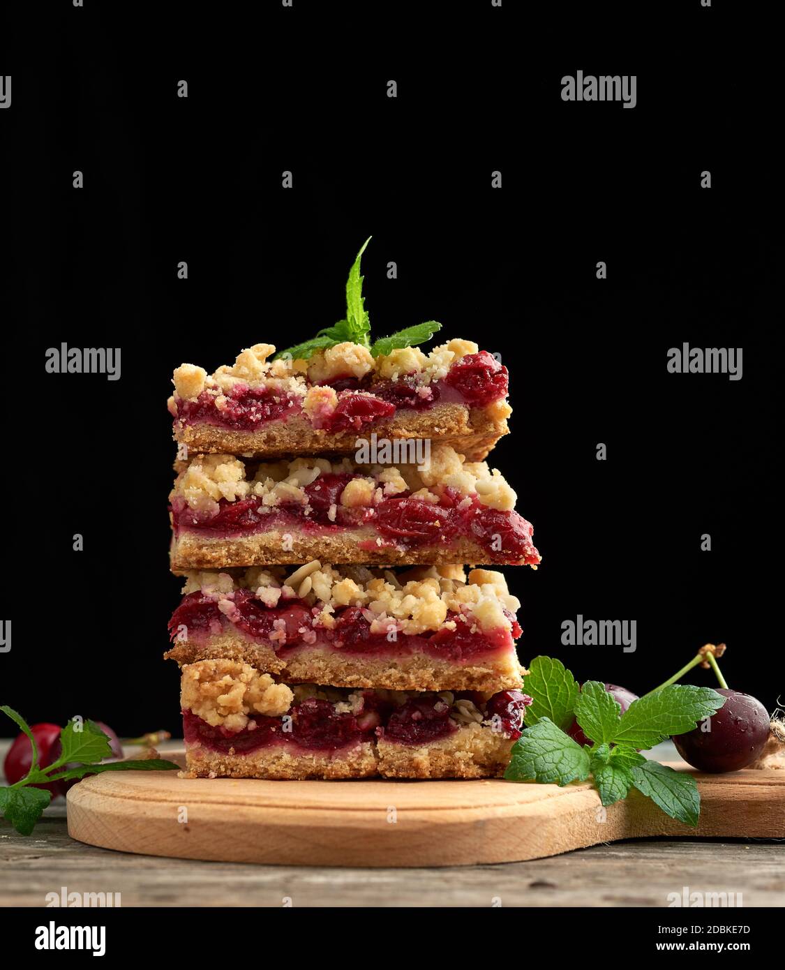 stack of square slices of a pie with red cherry, black background ...