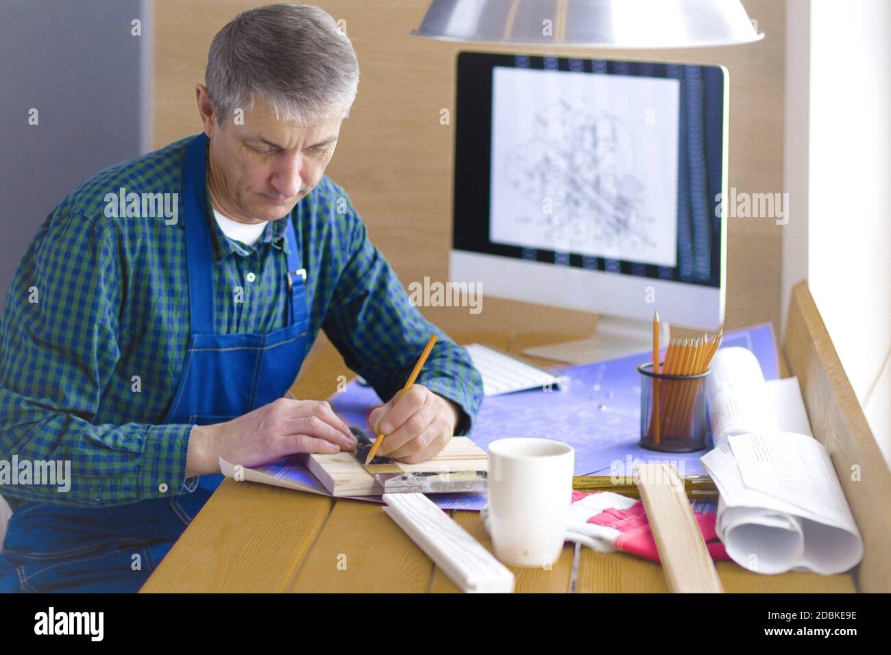 Engineer carpenter working on laptop and sketching project Stock Photo ...