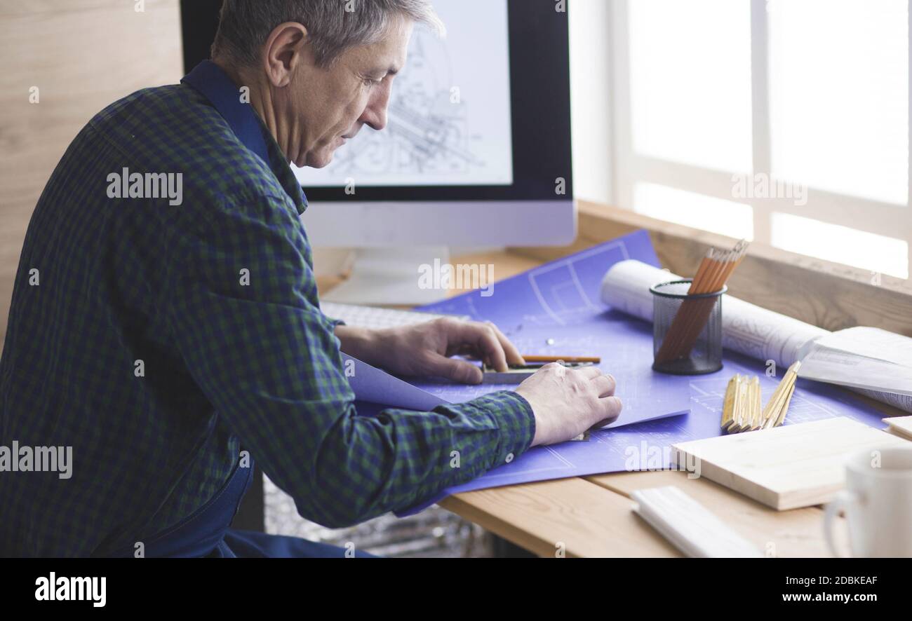 Engineer carpenter working on laptop and sketching project Stock Photo ...
