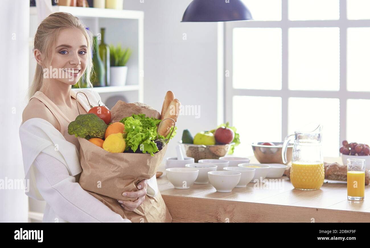 Beautiful woman in kitchen is drinking red wine Stock Photo - Alamy