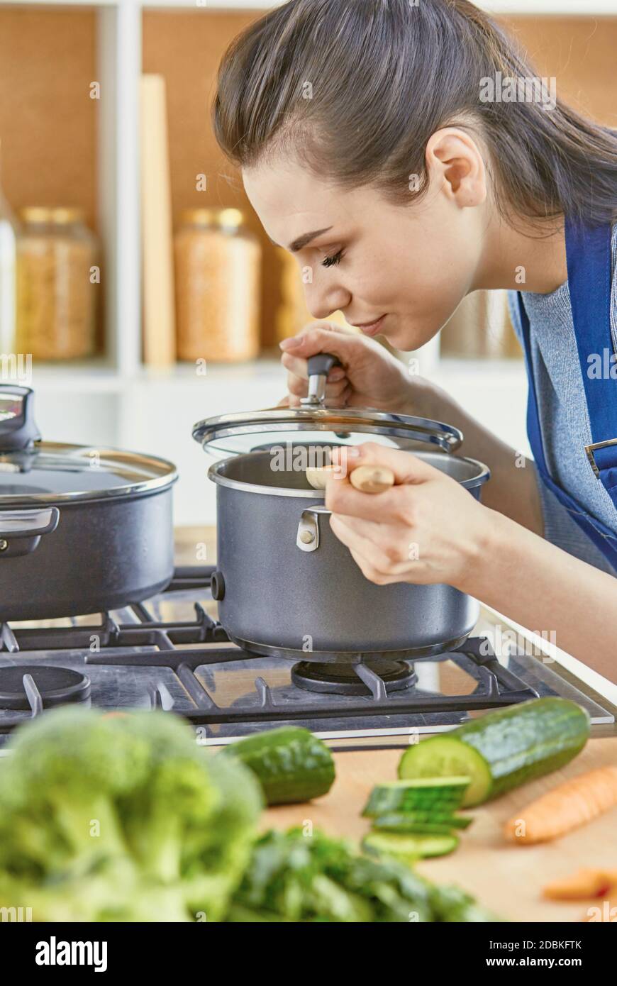 Beautiful woman in the kitchen, waiting with the front of the oven ...